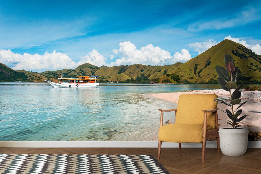 A boat on a body of water with a sandy beach and hills in the background - Magicdecor®