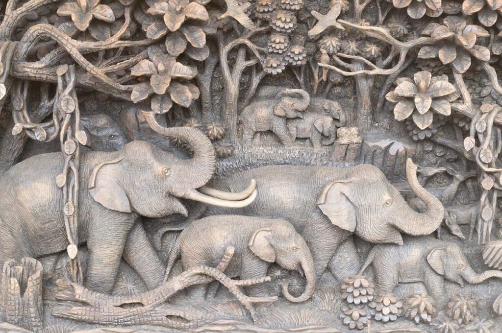 A group of elephants carved into a wall - Magicdecor®