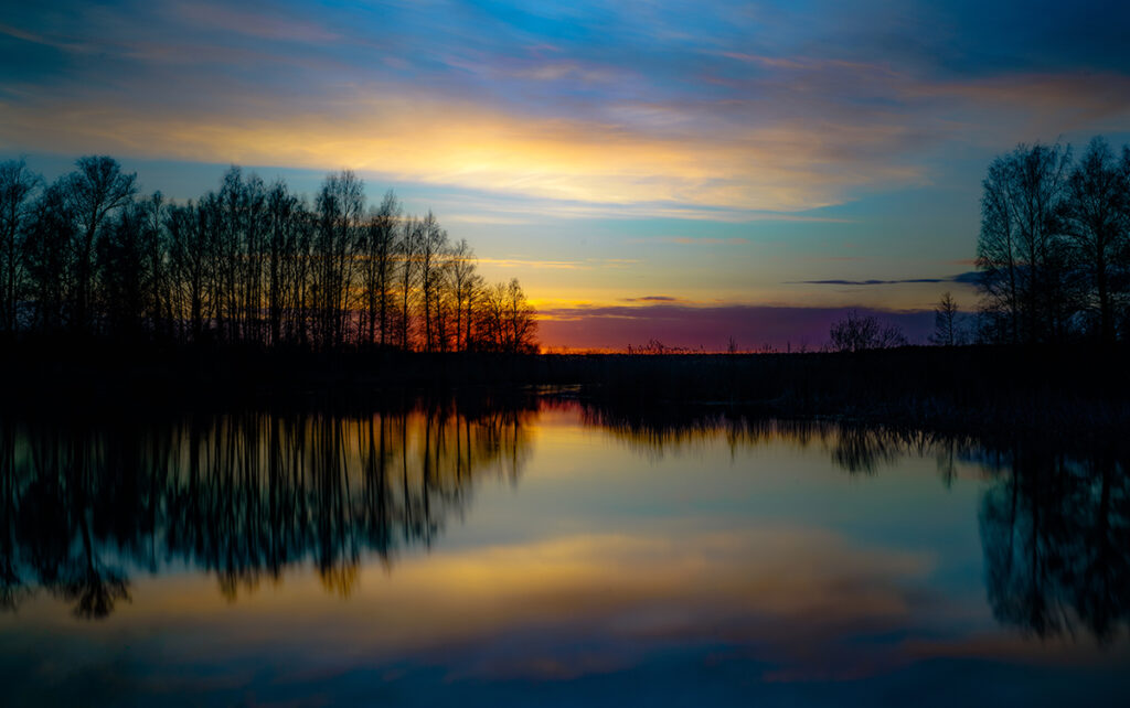 A body of water with trees and a sunset - Magicdecor®